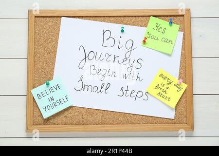 Corkboard with motivational quotes on wooden table, top view Stock ...