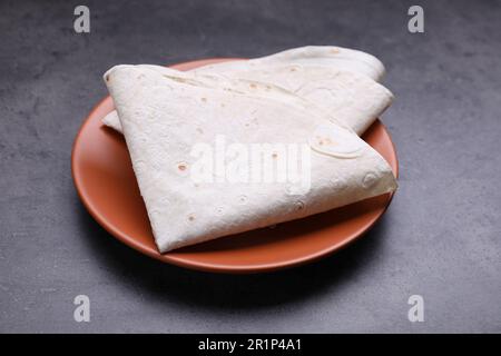 Delicious folded Armenian lavash on light blue wooden table, closeup ...