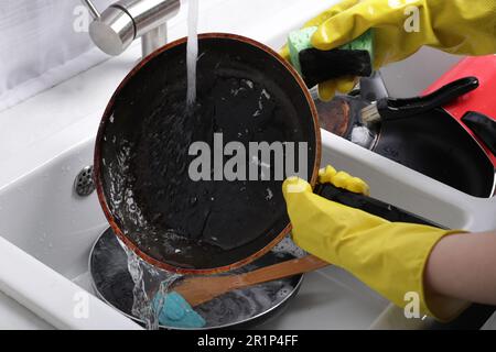 Woman washing frying pan in kitchen sink, above view Stock Photo - Alamy