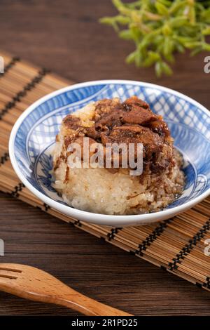 Migao, tube rice cake, rice pudding in a bowl topped with minced pork ...