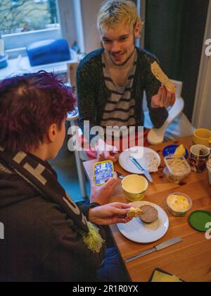 Non-binary couple having breakfast in kitchen Stock Photo - Alamy