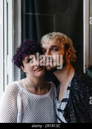 Non-binary couple at window Stock Photo - Alamy