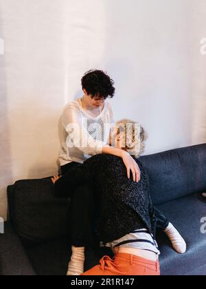 Non-binary couple on sofa Stock Photo - Alamy