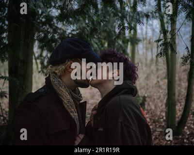 Non-binary couple kissing in forest Stock Photo - Alamy