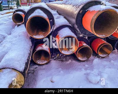 long, black, narrow pipes for laying plumbing communications. metal ...