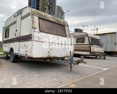 Old white rusty caravan trailers, mobile homes are parked Stock Photo ...