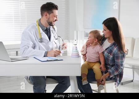 Mother and her cute baby having appointment with pediatrician in clinic ...
