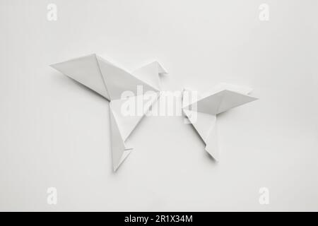 Beautiful origami birds on white background, flat lay. Space for text ...