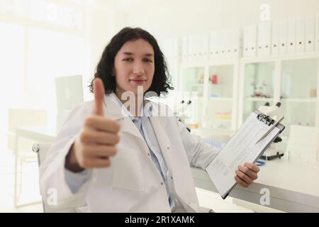 Satisfied scientist shows thumb up gesture looking in camera Stock ...