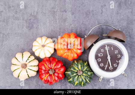 An alarm clock and pumpkins on black table Stock Photo - Alamy
