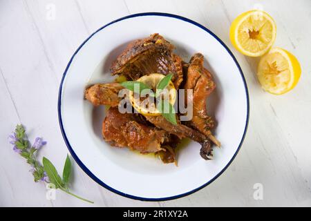 Fried rabbit cooked with lemon and sage sauce Stock Photo - Alamy