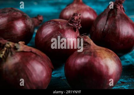 Red onions on a blue background Stock Photo - Alamy