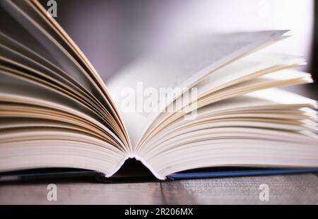Composition with open book on the table Stock Photo - Alamy