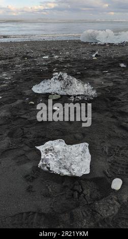 The chunks of ice sitting in the sand at the Diamond beach Stock Photo ...