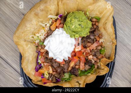 Crispy tostada shell contains this generous fajita taco salad with ...