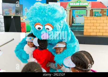 A large Sesame Street style character performing for African children ...