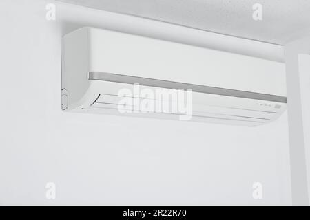 Modern air conditioner hanging on white wall Stock Photo - Alamy