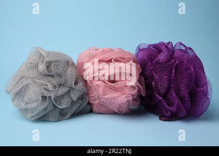 Colorful shower puffs on light blue background Stock Photo - Alamy