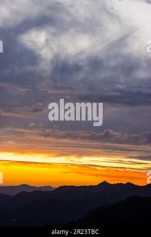 Colorful magnificent sunset in countryside above hills and fields ...