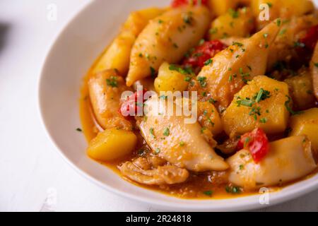 Baby Squid stew with potatoes and prawns. Traditional Spanish recipe ...