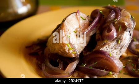 Hake fish cooked with red onion in a spanish restaurant Stock Photo - Alamy