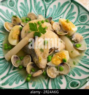 Basque-style hake cooked with green parsley and garlic sauce, served ...