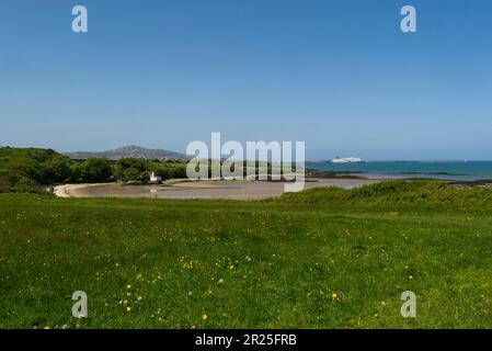 View across sandy beach to Holyhead ferry Port from Penrhos Country ...