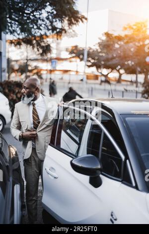 Lisbon; A black man with a bald head, wearing a pink jacket and a full ...