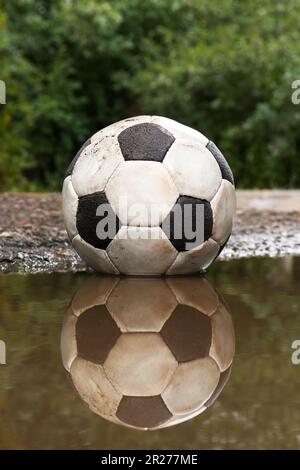 Dirty soccer ball in muddy puddle outdoors Stock Photo - Alamy