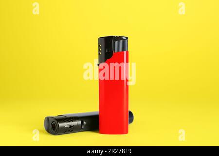 Stylish small pocket lighters on yellow background, flat lay Stock ...