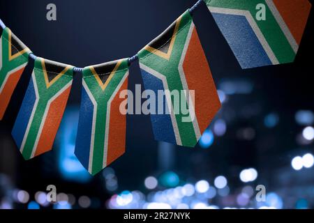 A garland of South Africa national flags on an abstract blurred ...