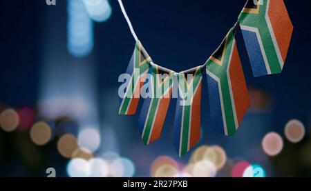 A garland of South Africa national flags on an abstract blurred ...