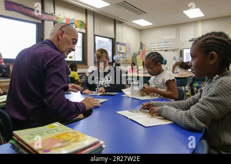 Richard Evans, a teacher at Hyde Park Elementary School, works helps Ke'Arrah Jessie sound out a ...