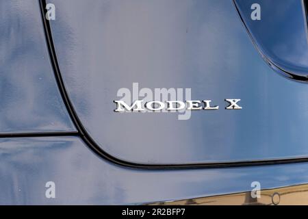 The Tesla logo insignia badge on the bonnet of an EV vehicle at a ...