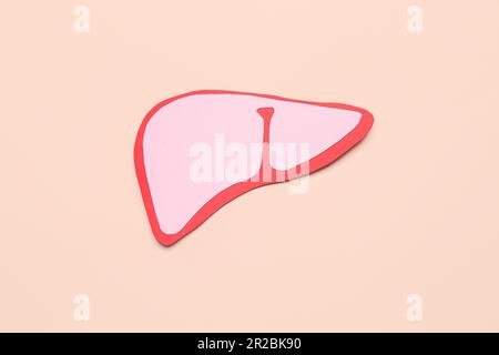 Pink paper liver on beige background Stock Photo - Alamy