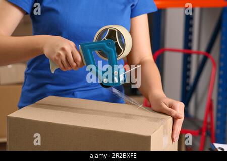 Post office worker packing parcel at counter indoors Stock Photo - Alamy