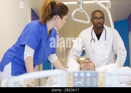 Medics pushing hospital bed along corridor Stock Photo - Alamy