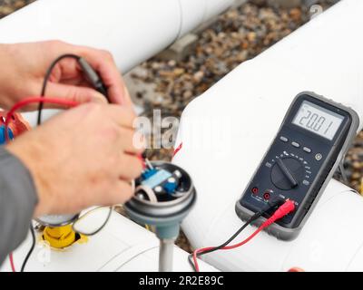 Checking gas equipment sensor with multimeter. Close-up hands ...