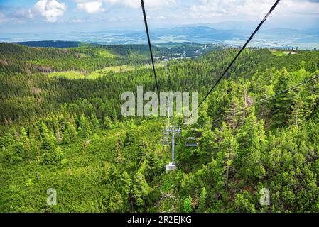 Tourist double lift above the forest on the mountain slope Stock Photo ...