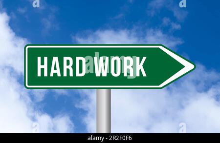 Hard work road sign on sky background Stock Photo - Alamy
