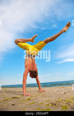 yoga man standing on hands and does the splits Stock Photo - Alamy
