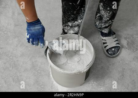 Professional worker mixing plaster in bucket indoors, closeup Stock ...