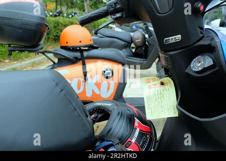 Motor scooter with parking ticket in Kaohsiung, Taiwan; yellow slips ...