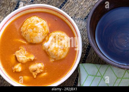 Light soup with chicken and fufu, West African soup dish, served in ...