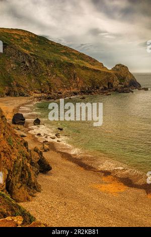 A vertical shot of rocky cliffs by the seaside on a cloudy day Stock ...