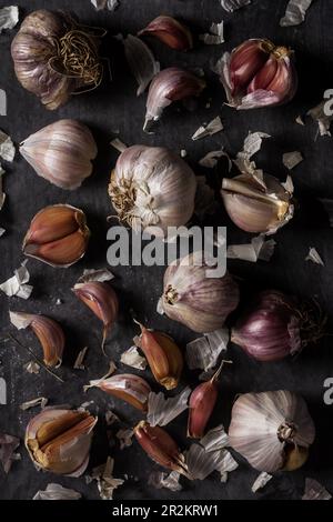 Fresh garlic bulbs and cloves grouped on black background. Flat lay ...