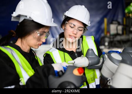 Couple of happy female maintenance engineers working at factory Stock ...