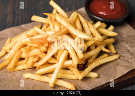 Tasty french fries on cutting board, on wooden table background Stock ...