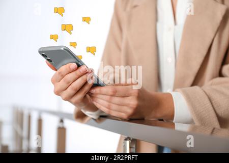 Social media dislike reaction. Woman using mobile phone indoors ...