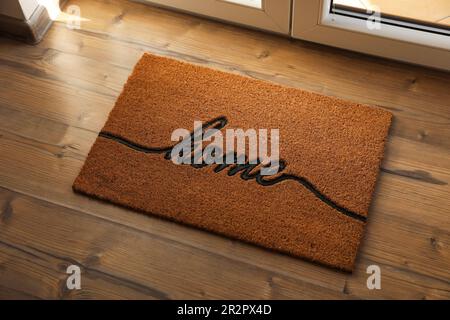 Doormat with word Home on parquet floor indoors Stock Photo - Alamy